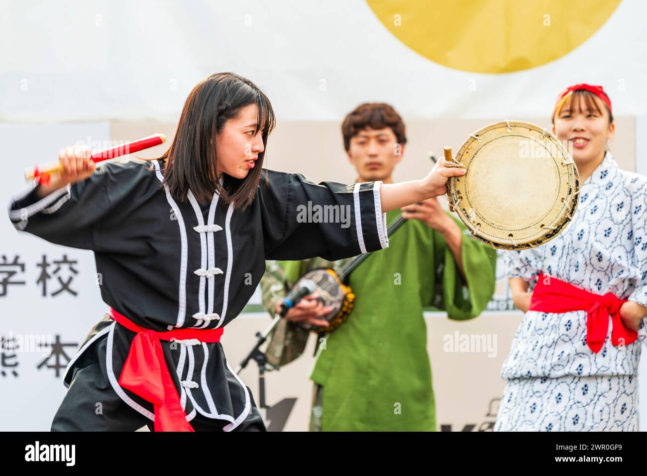 Close up of a young Japanese woman about to bang a small hand held ...