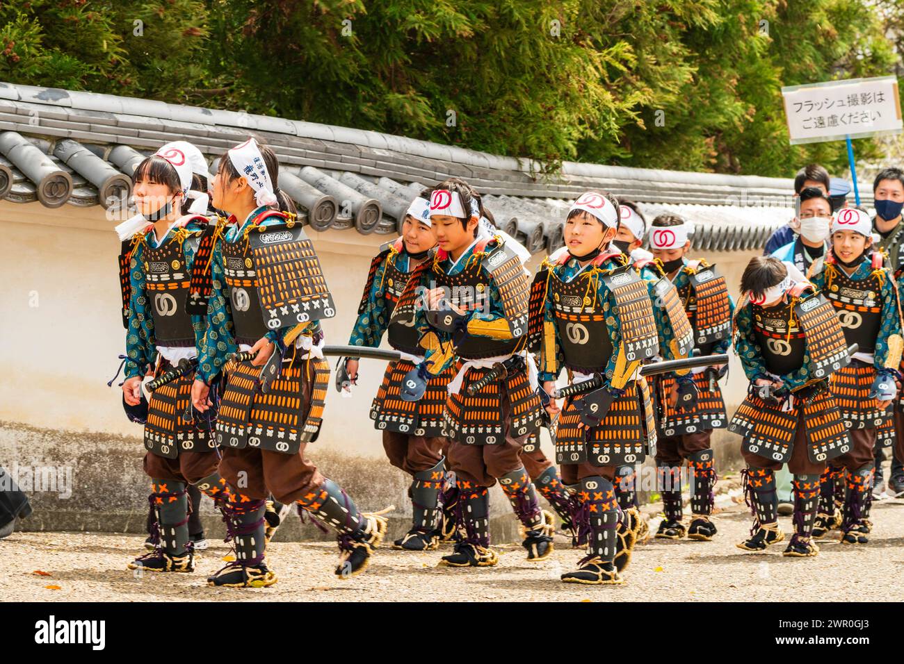 Japanese children dressed as ashigaru soldiers marching along a street ...