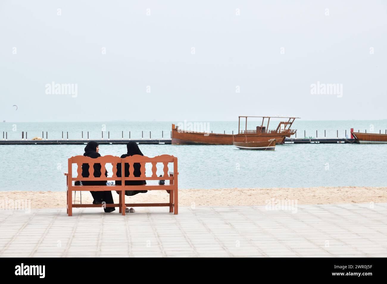 Doha, Qatar - Nov 20. 2019. women in national clothes sitting on bench ...