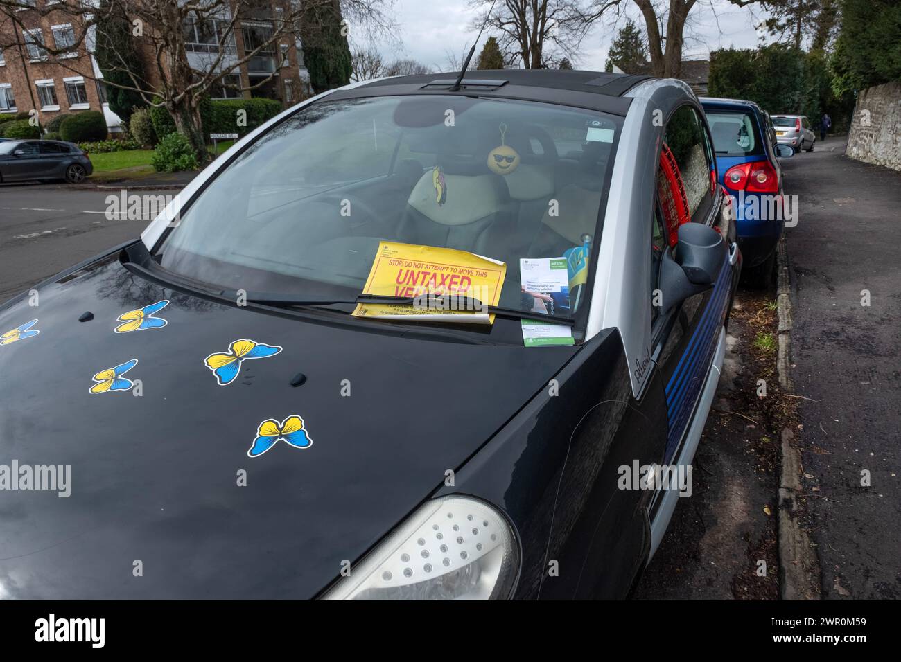 Untaxed car with a wheel clamp on a street Stock Photo - Alamy