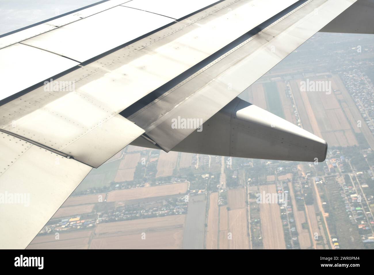 plane wing and city background on sky through window frame Stock Photo ...