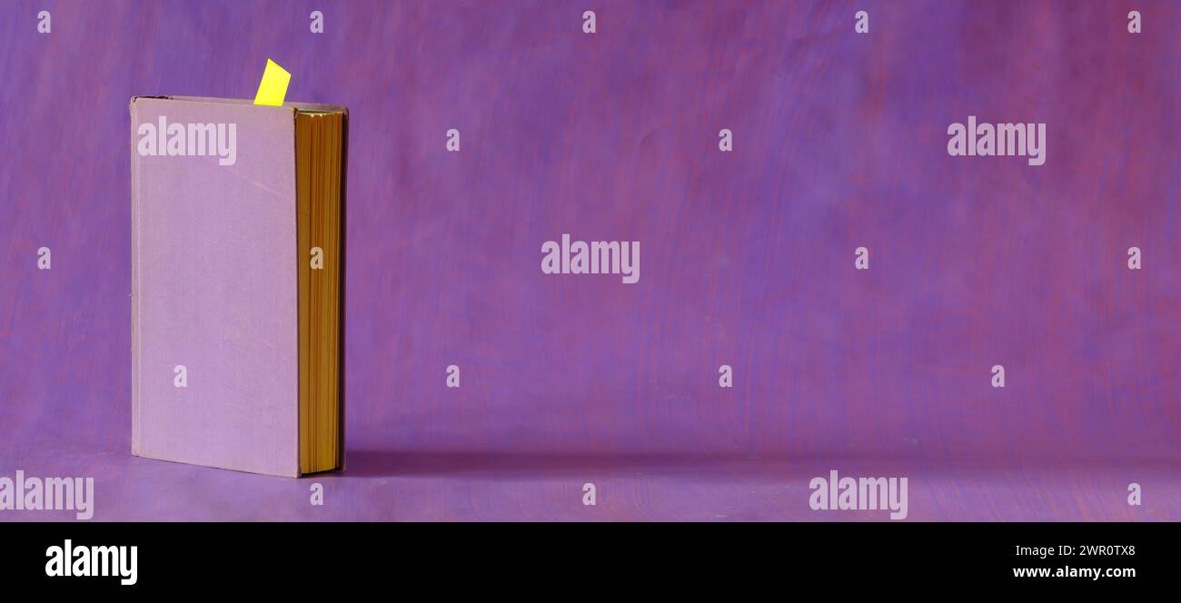 Single purple book in front of a purple background, reading,education ...