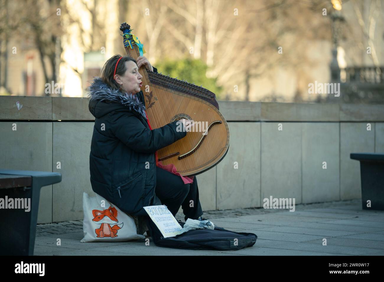A woman singing in Ukrainian and playing a bandura folk instrument is ...