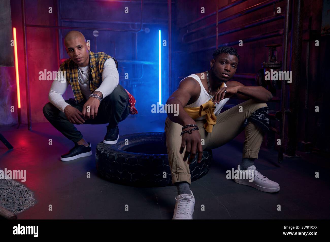 Two young drug dealers with serious faces posing for camera in neon ...
