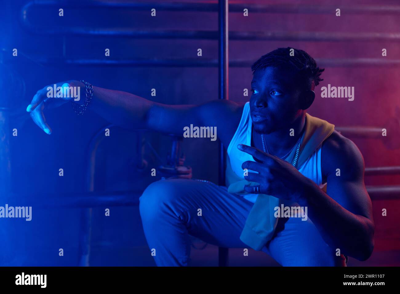 Young cool guy rapper posing for camera in neon light Stock Photo - Alamy