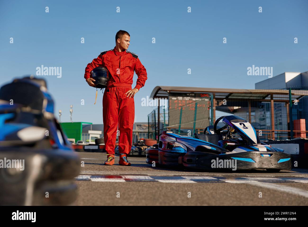 Go-kart driver walking to car before race at starting line on motor ...