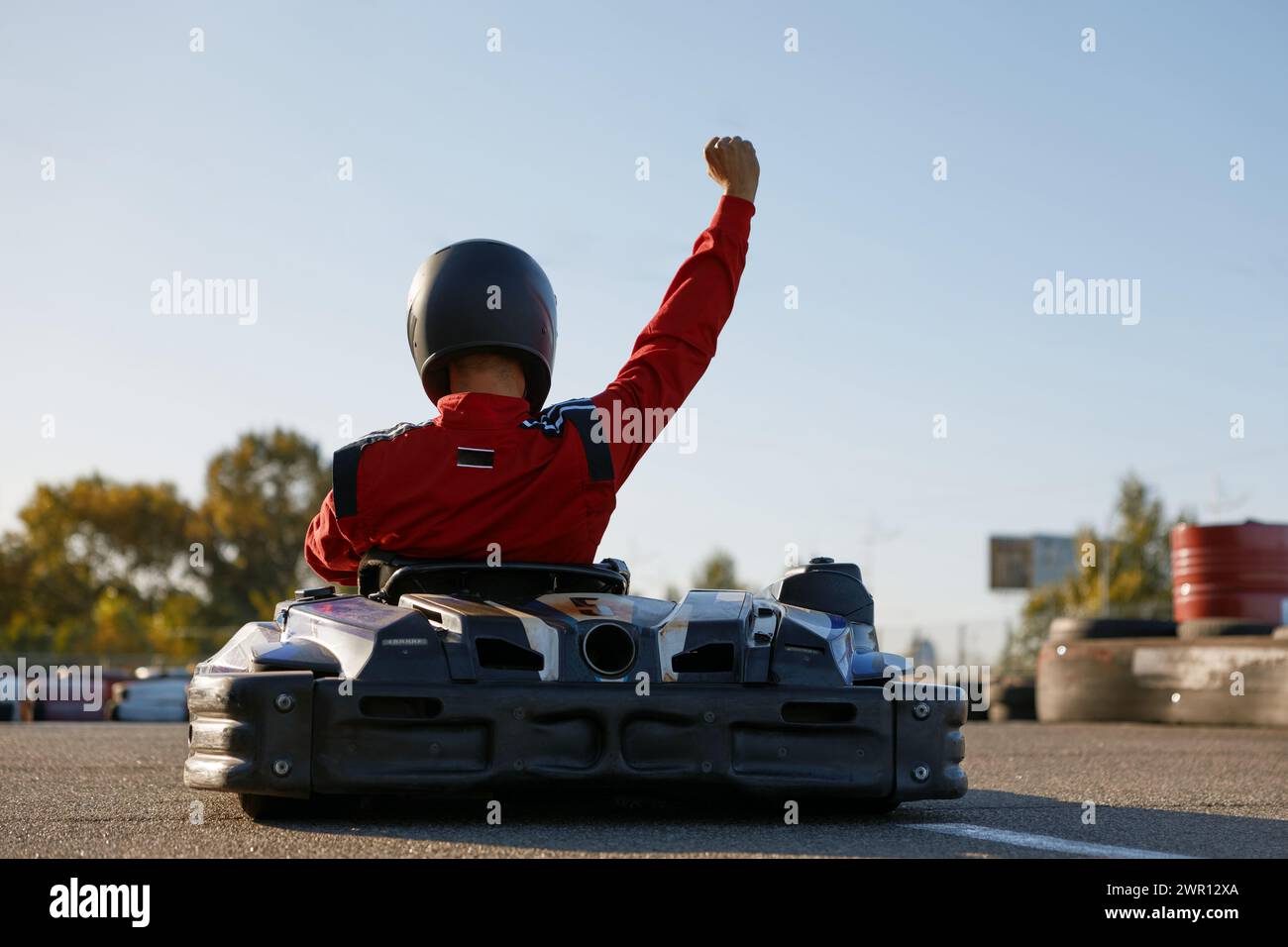 Happy go-cart driver raising hand up rejoicing and celebrating win ...