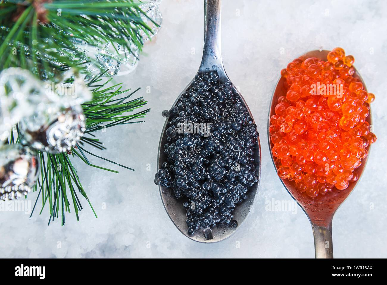 Two spoons with red salmon roe and black caviar Stock Photo - Alamy