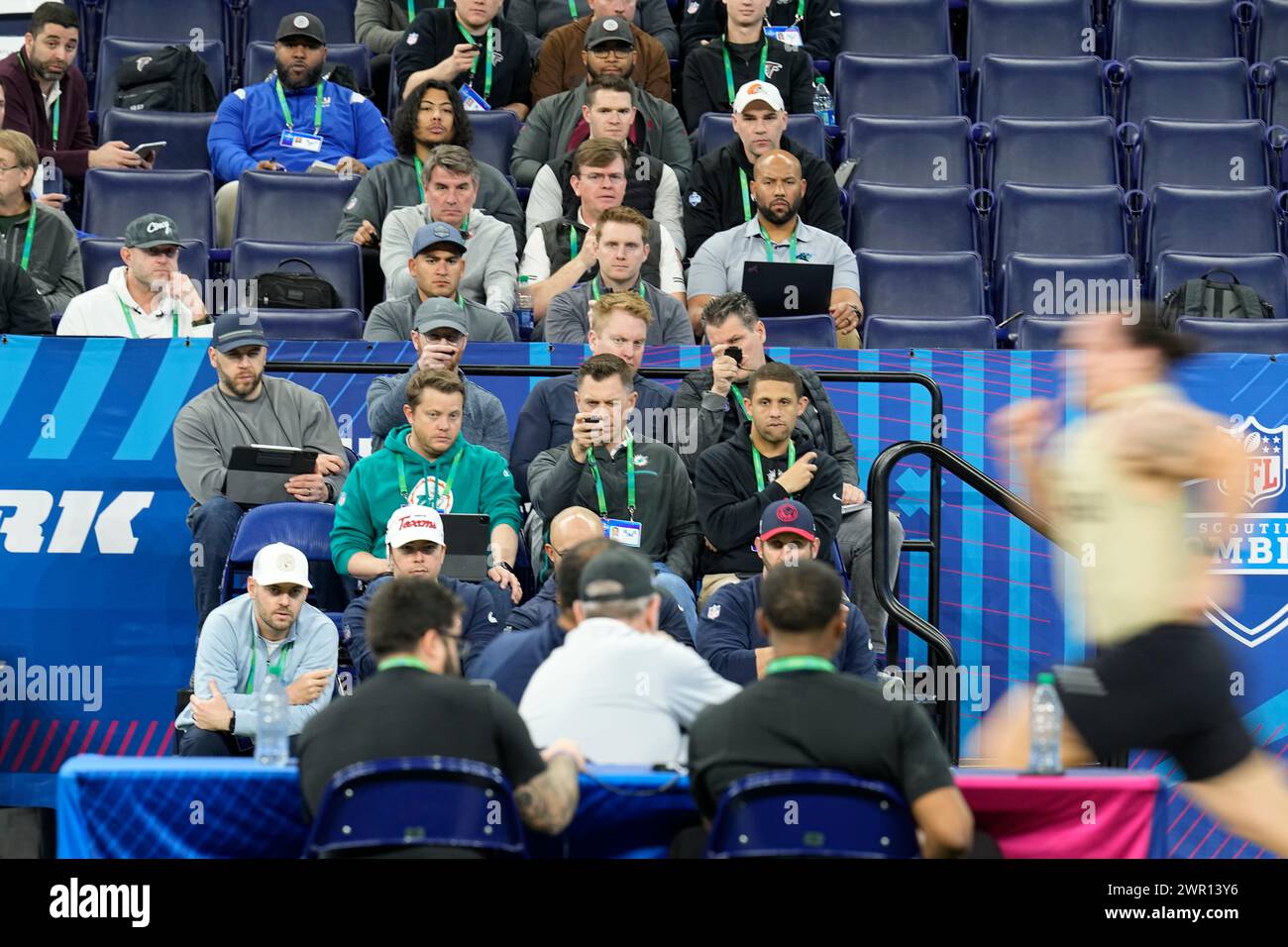 Scouts watch as players run a drill at the NFL football scouting ...
