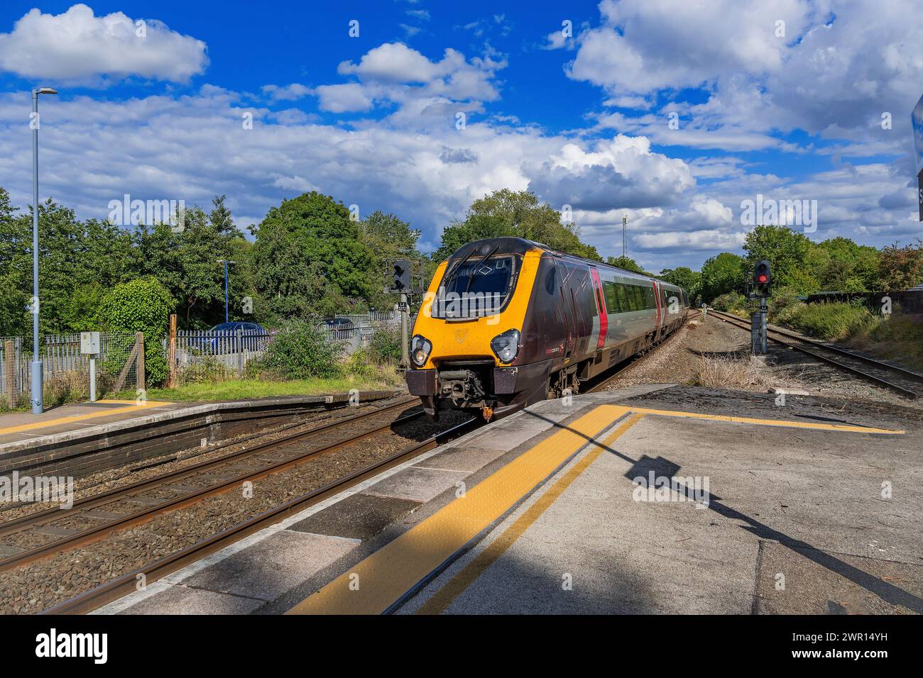 Express passenger train passing through commuter station west midlands ...