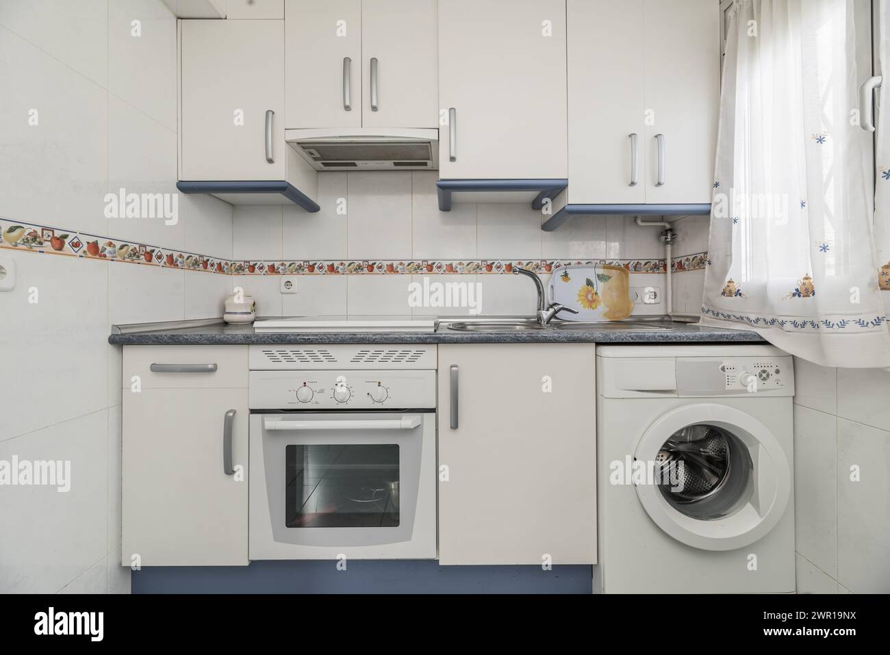 Frontal image of a kitchen in a house with appliances, white carpentry ...