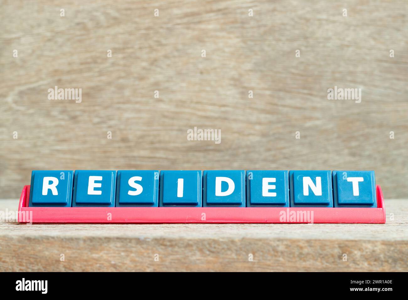 Tile alphabet letter with word resident in red color rack on wood ...
