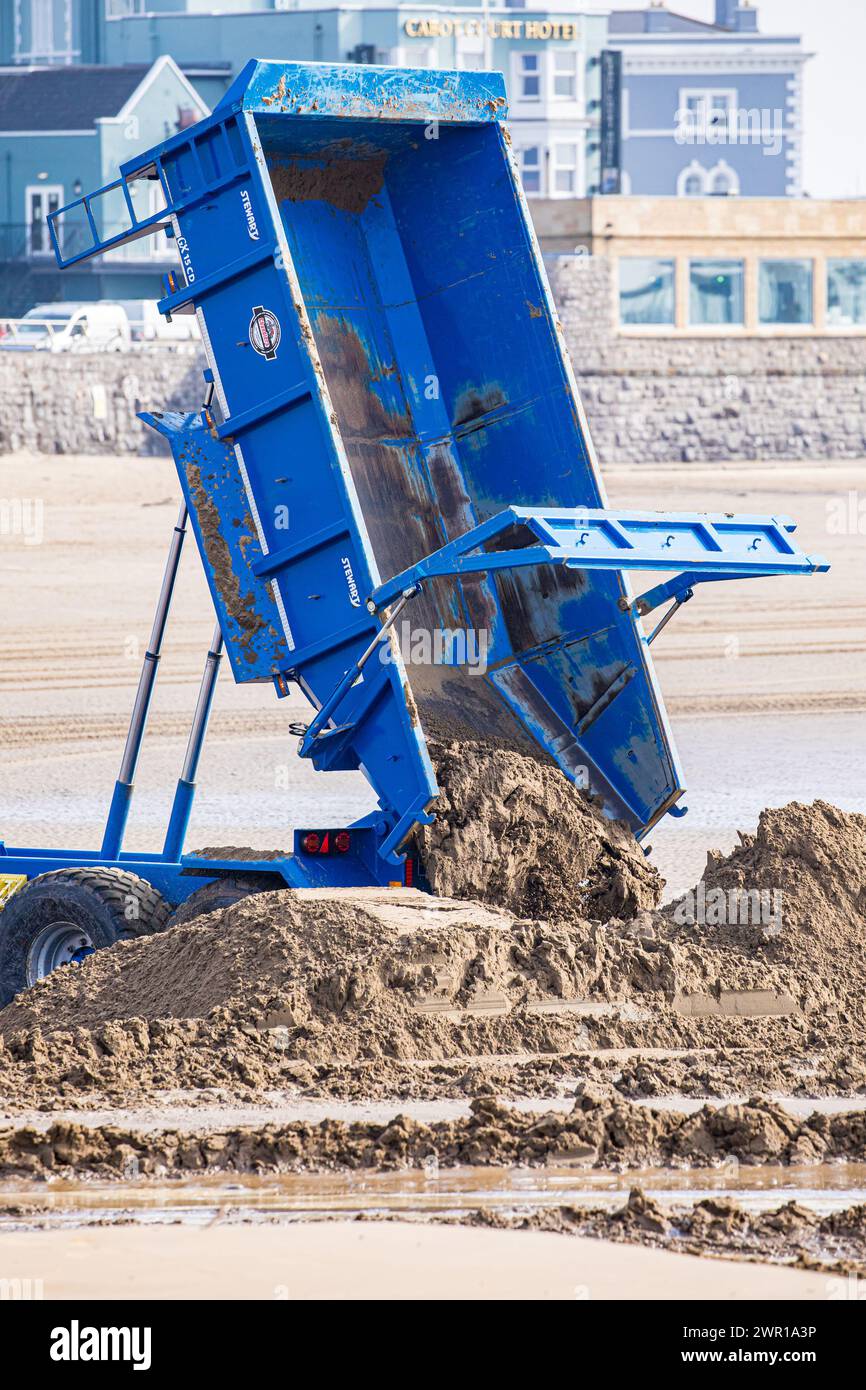 trailer tipping sand on Weston Super Mare Beach to combat the effect of ...