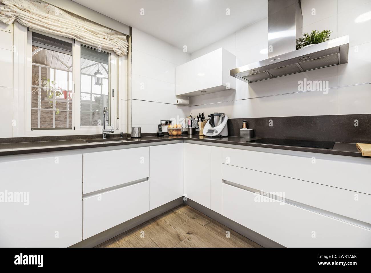 Corner of a furnished L-shaped kitchen in a detached house with ...