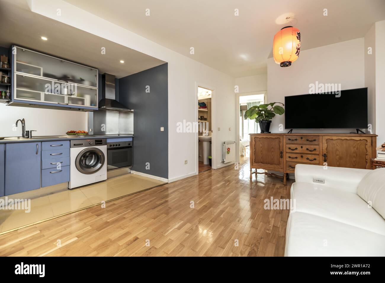 Loft-style apartment with open kitchen with blue furniture, parquet ...