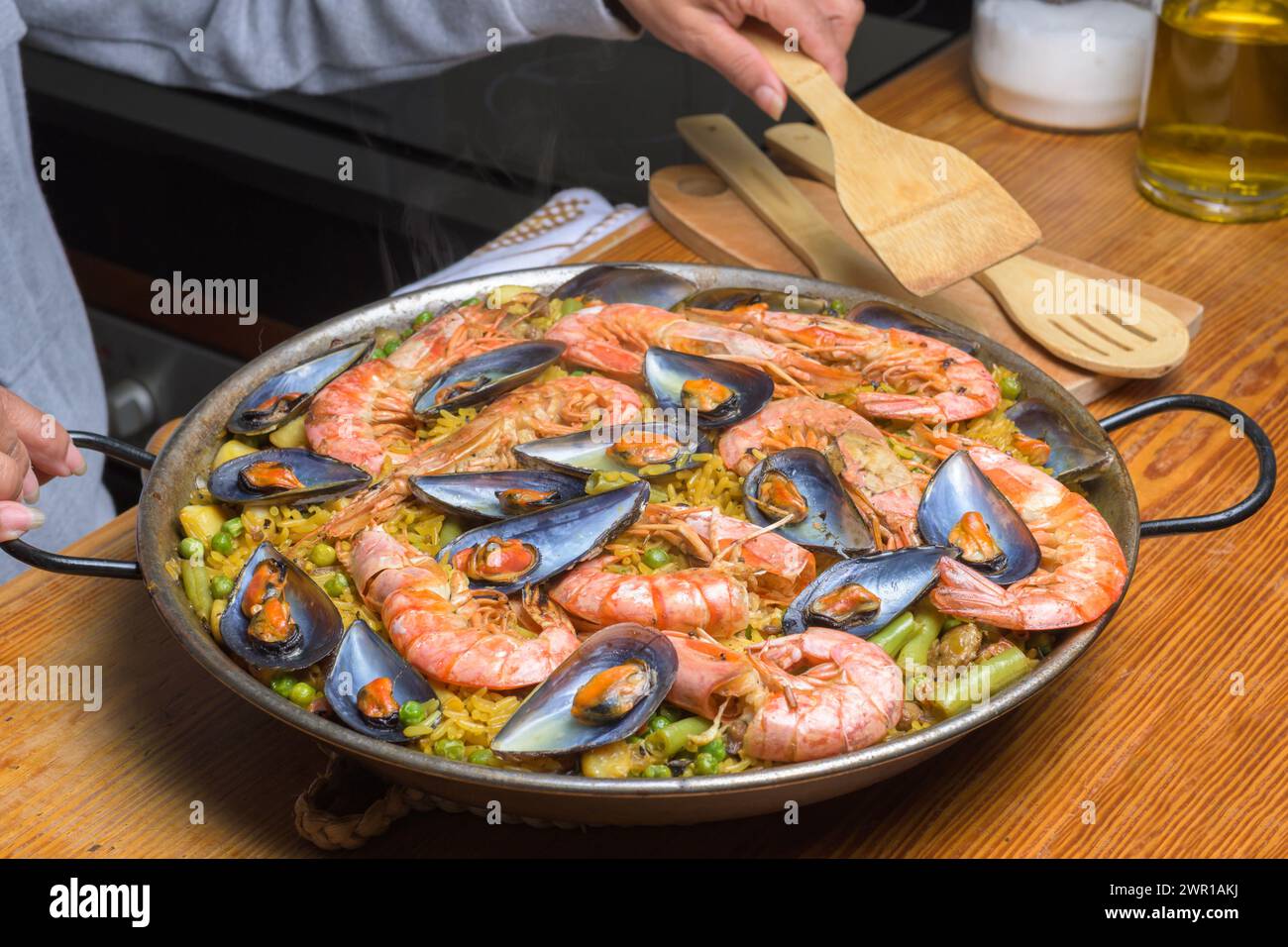 A traditional Spanish paella with shrimp and mussels in a rustic ...