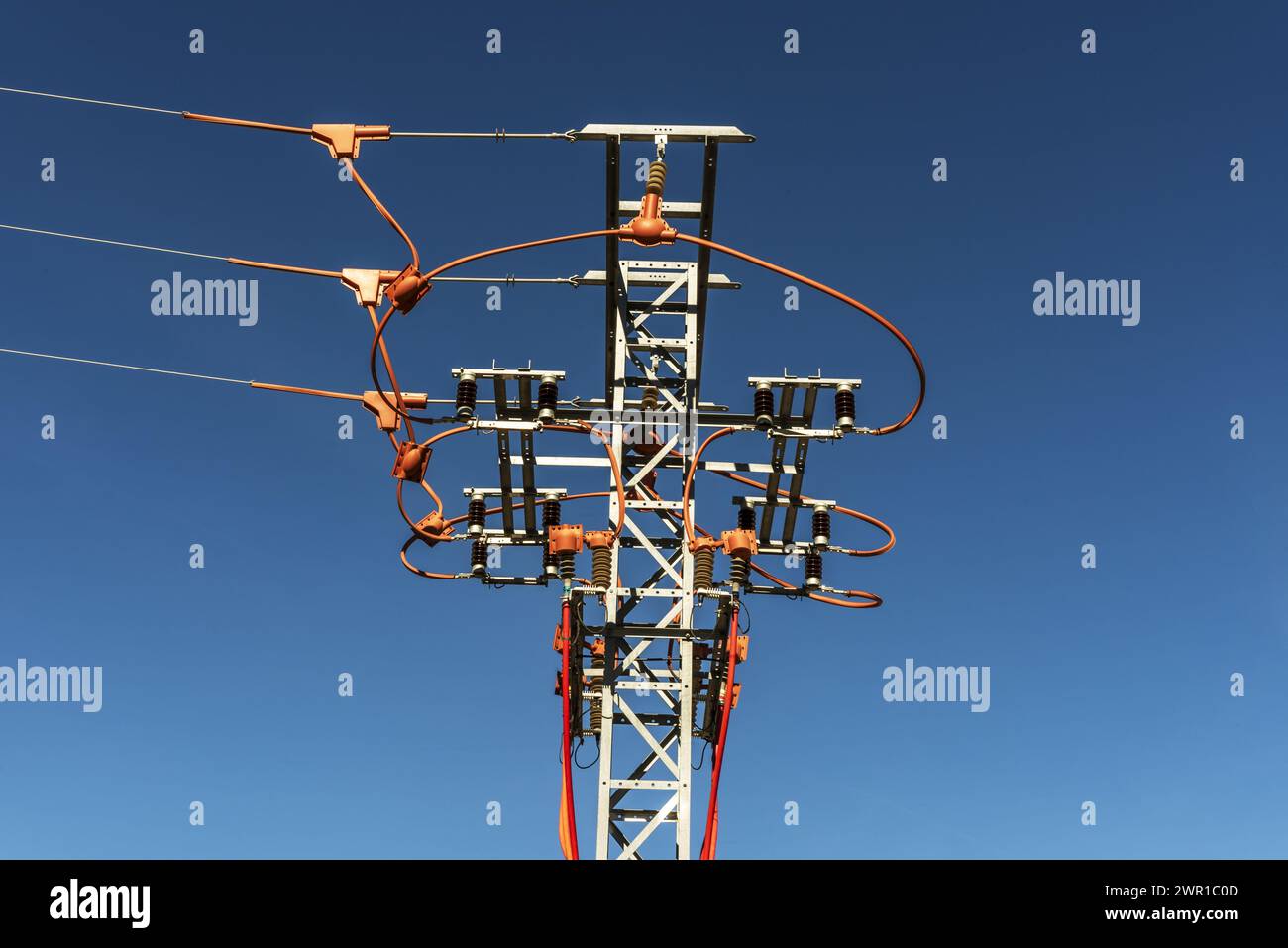A power line on overhead poles with red cables on a nice clear sky day ...