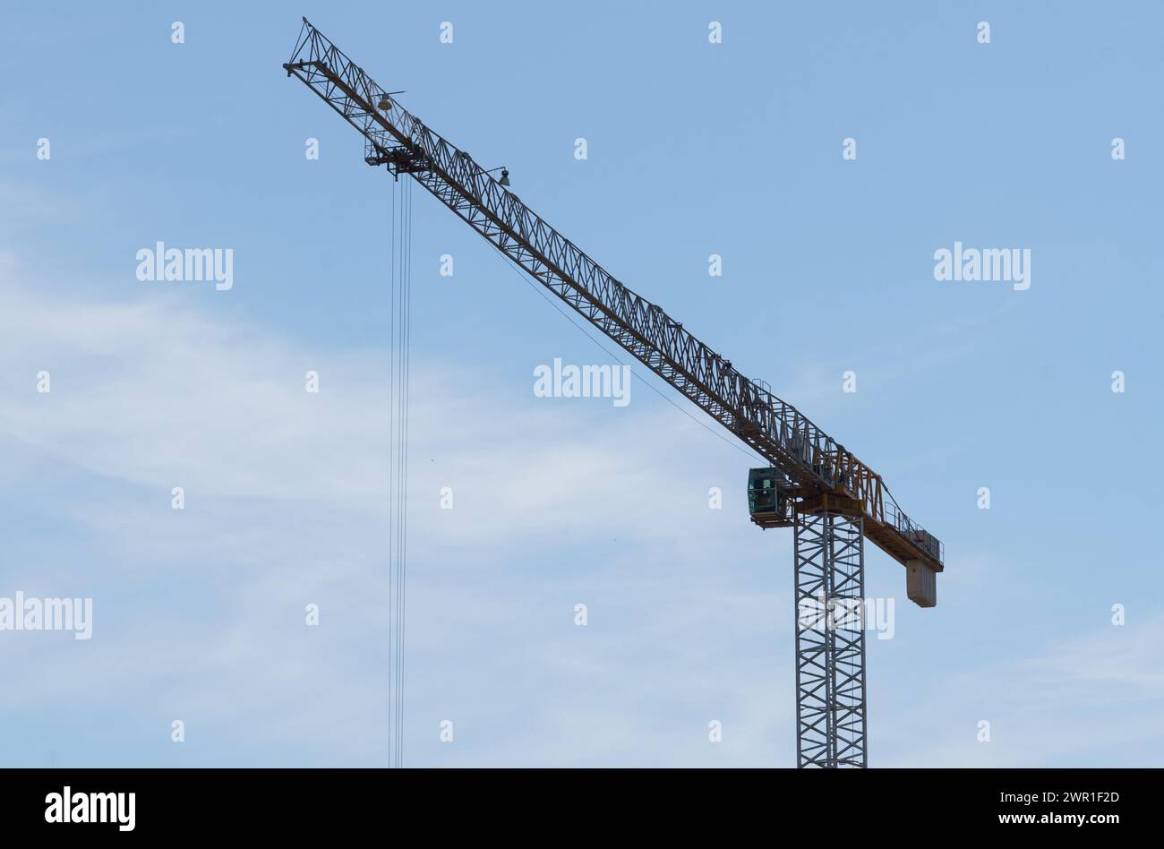 A construction crane is positioned on the roof of a tall building ...