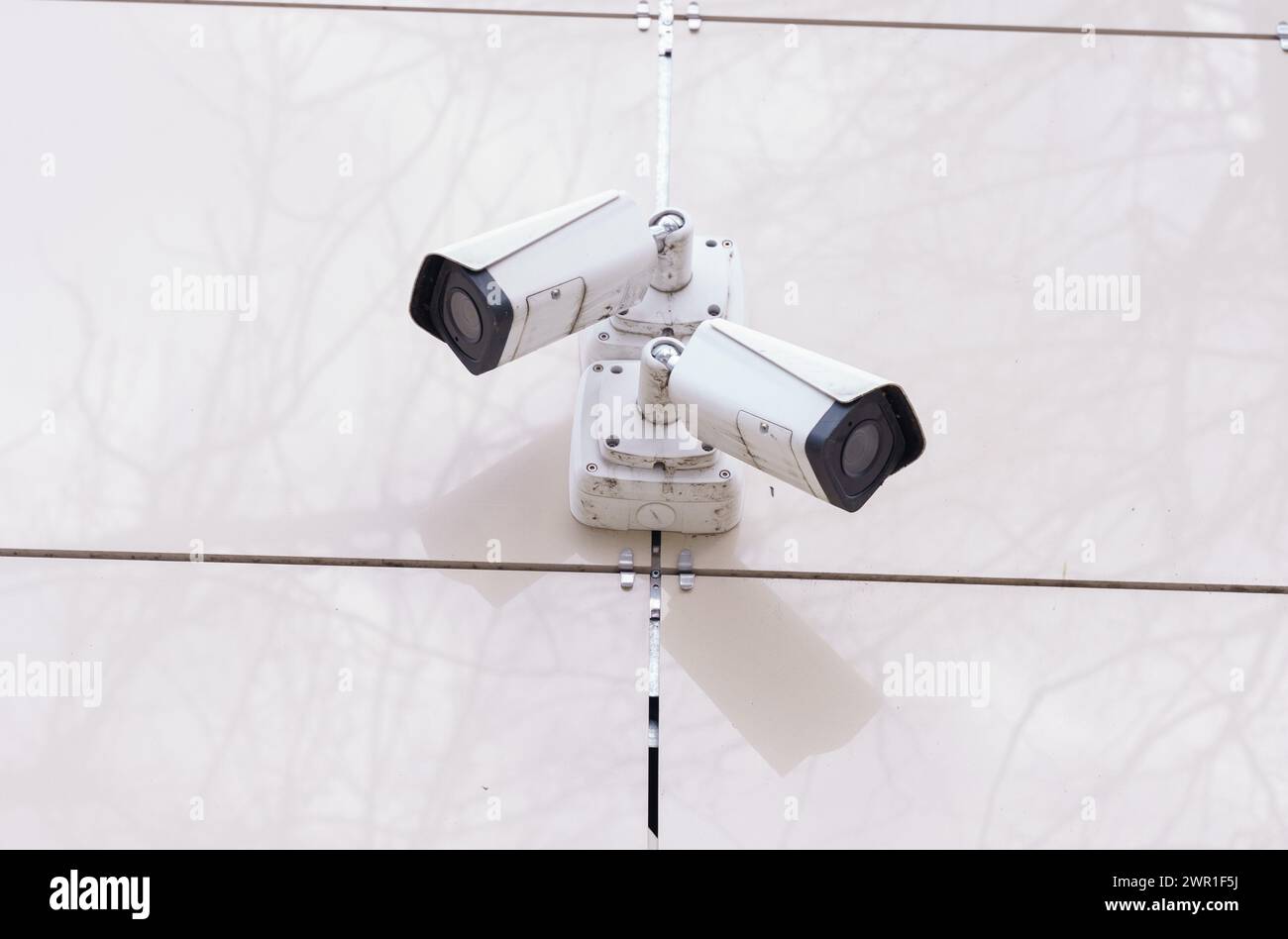 Two security cameras positioned back-to-back for surveillance mounted ...