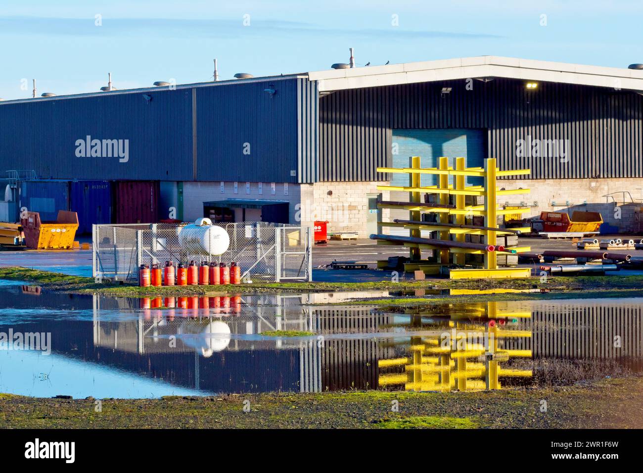 A view of the rear of a large industrial unit, a large puddle from a ...