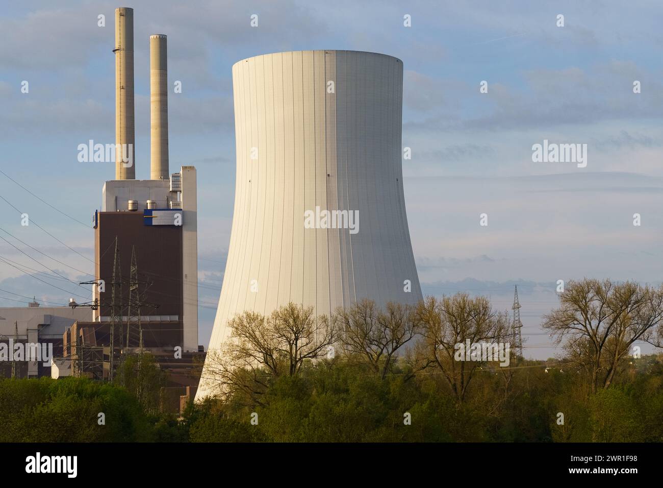 A nuclear power plant stands tall in the background while trees add a ...