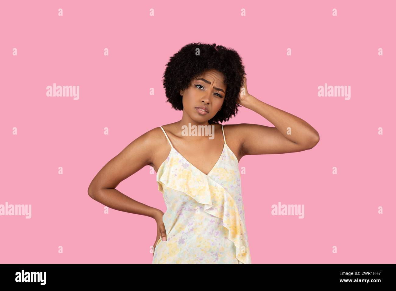 Confused African-American woman scratching her head, with a puzzled ...