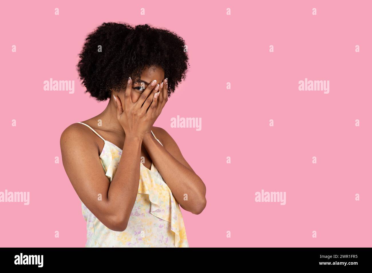 Curly Haired African American Woman Playfully Covers Her Face With