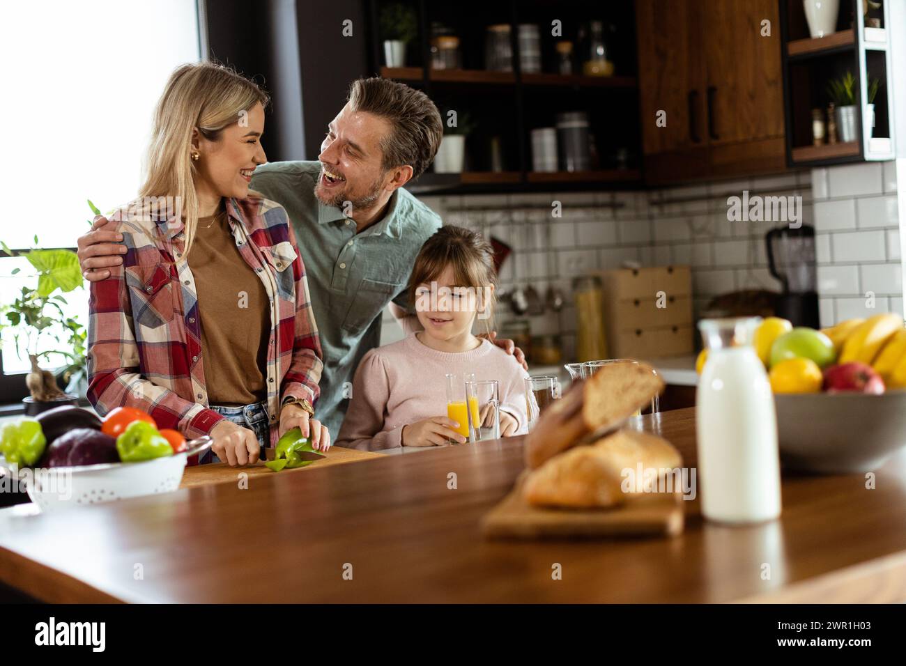 Family shares a smile while preparing breakfast together in a cozy ...