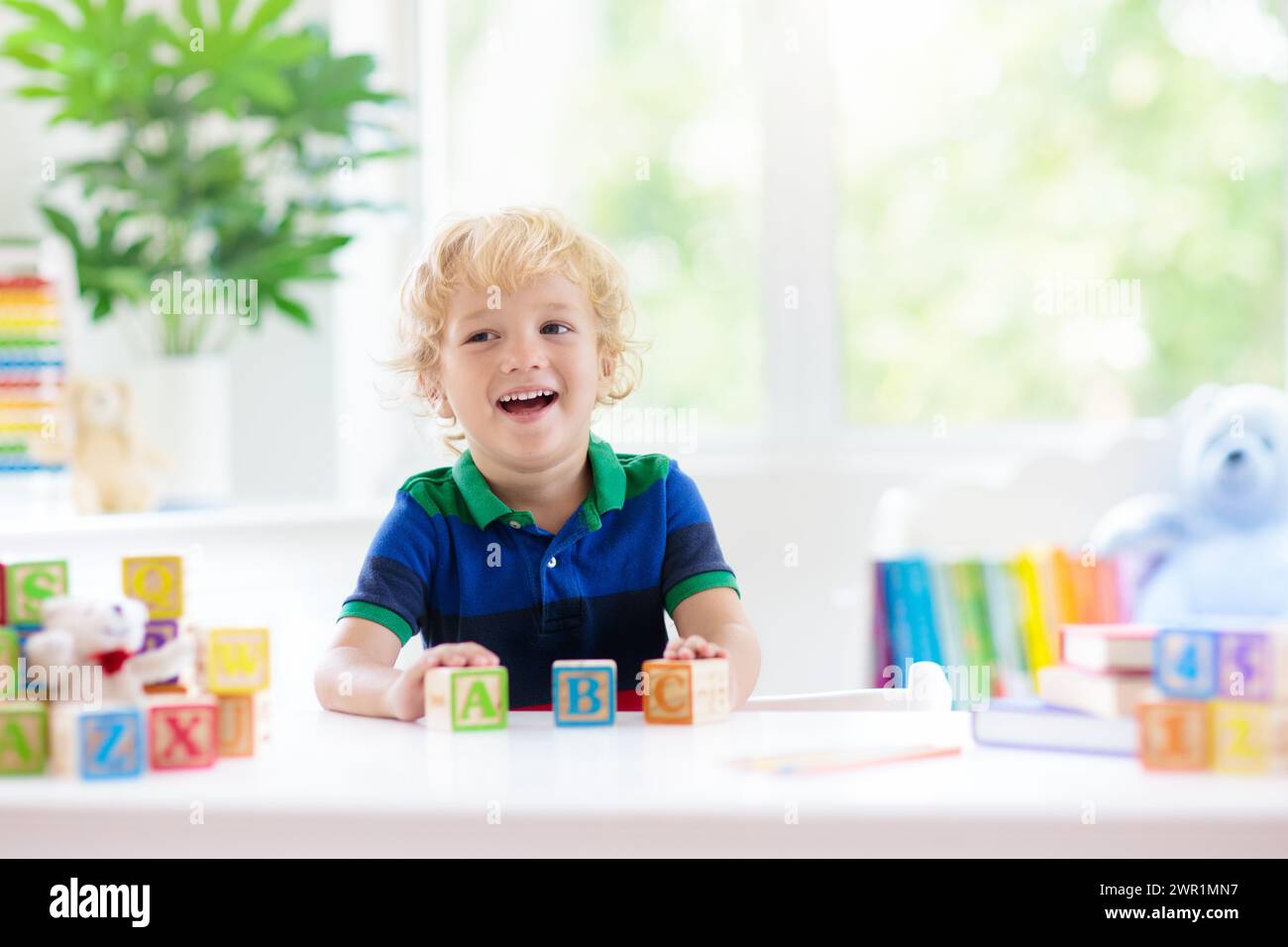 Child learning letters and numbers. Kid with colorful wooden abc blocks ...