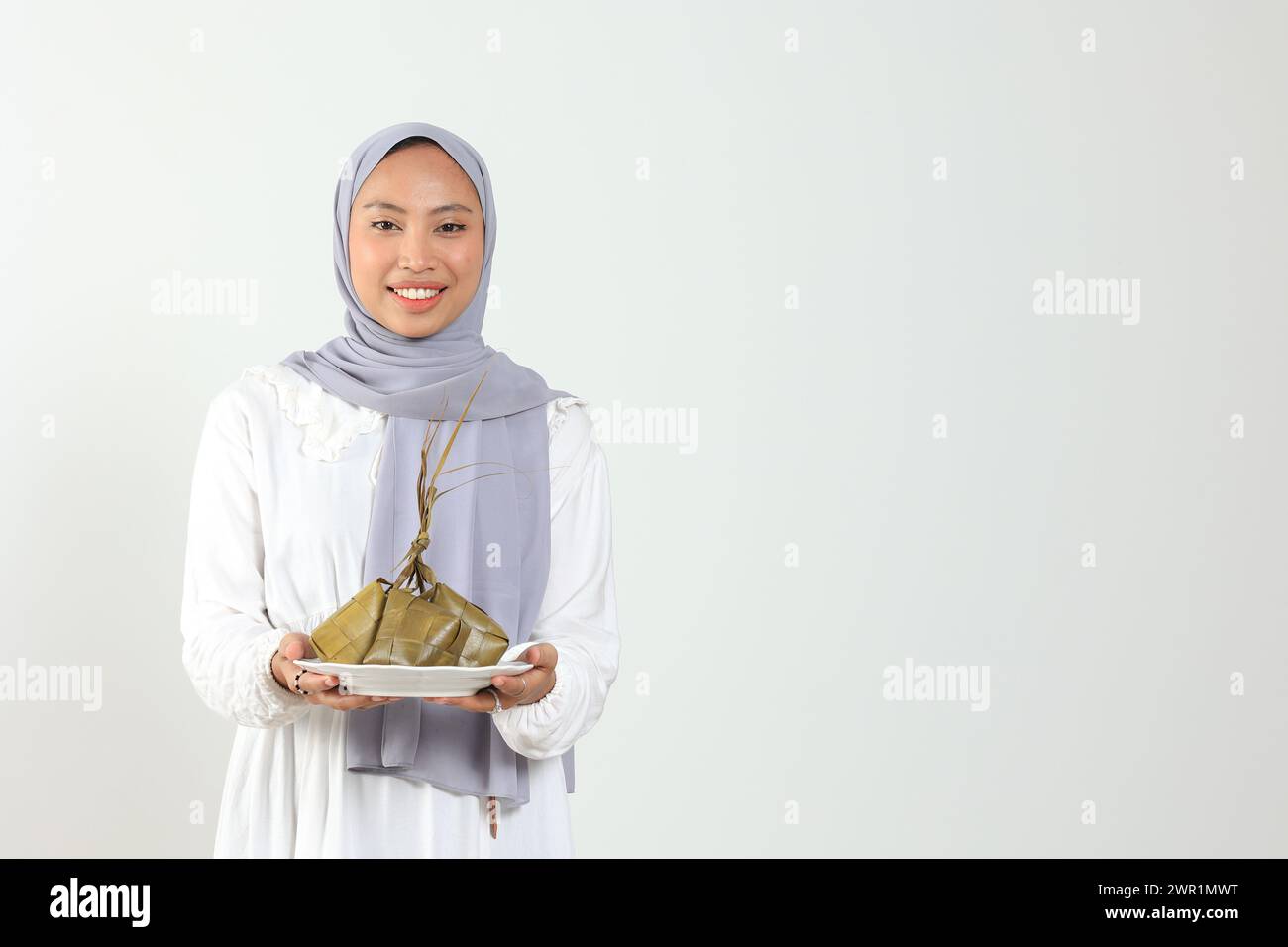 Indonesian Female Holding White Plate with Ketupat, Rice Cake with ...