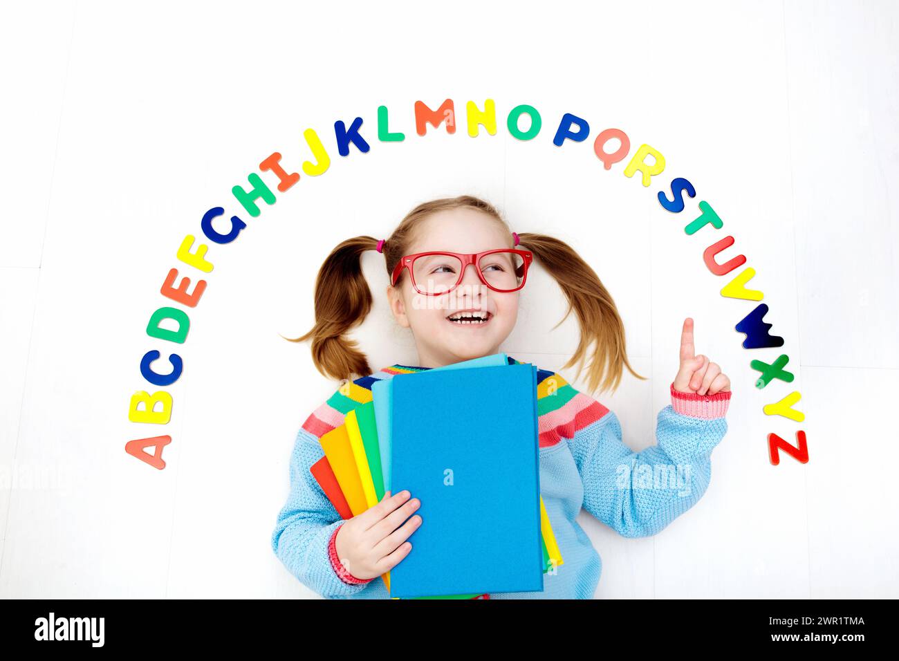 Happy preschool child learning to read and write playing with colorful ...