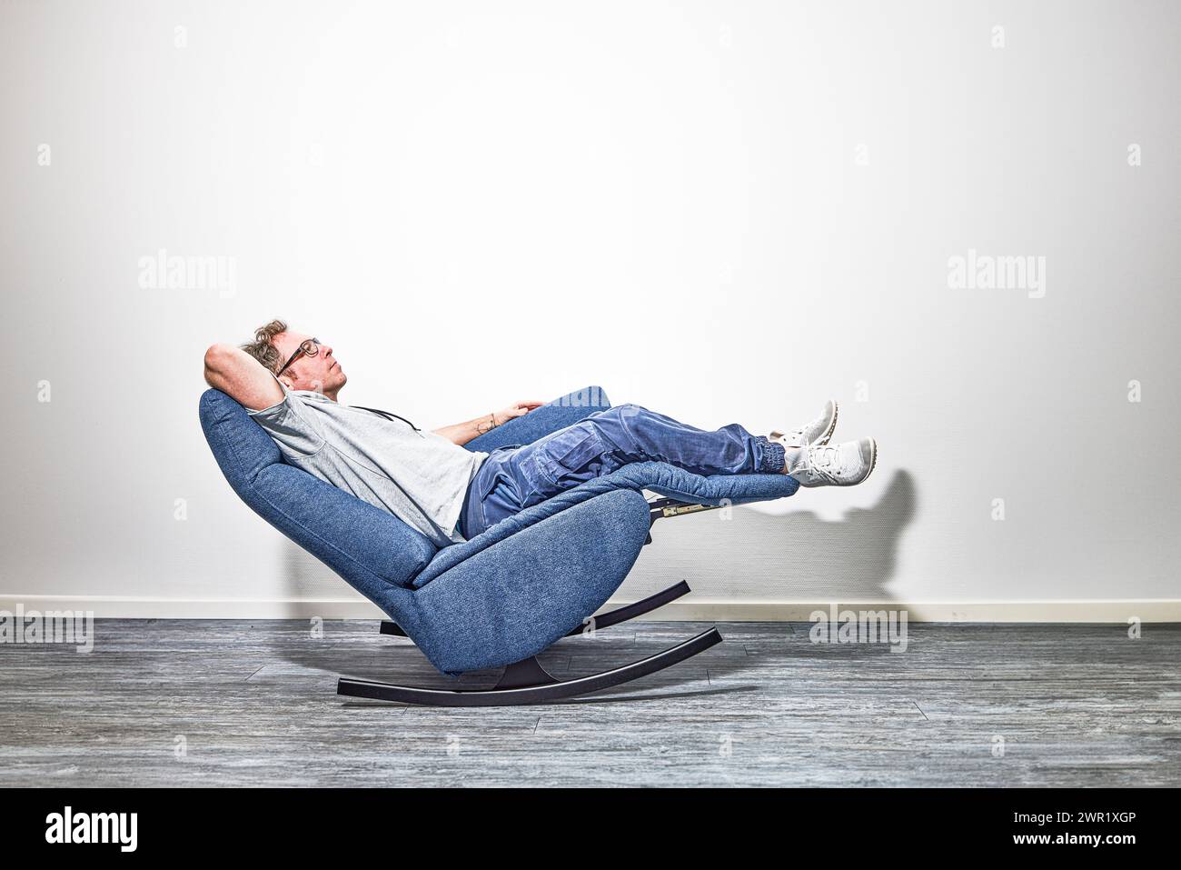 Man relaxing in modern chair Stock Photo - Alamy