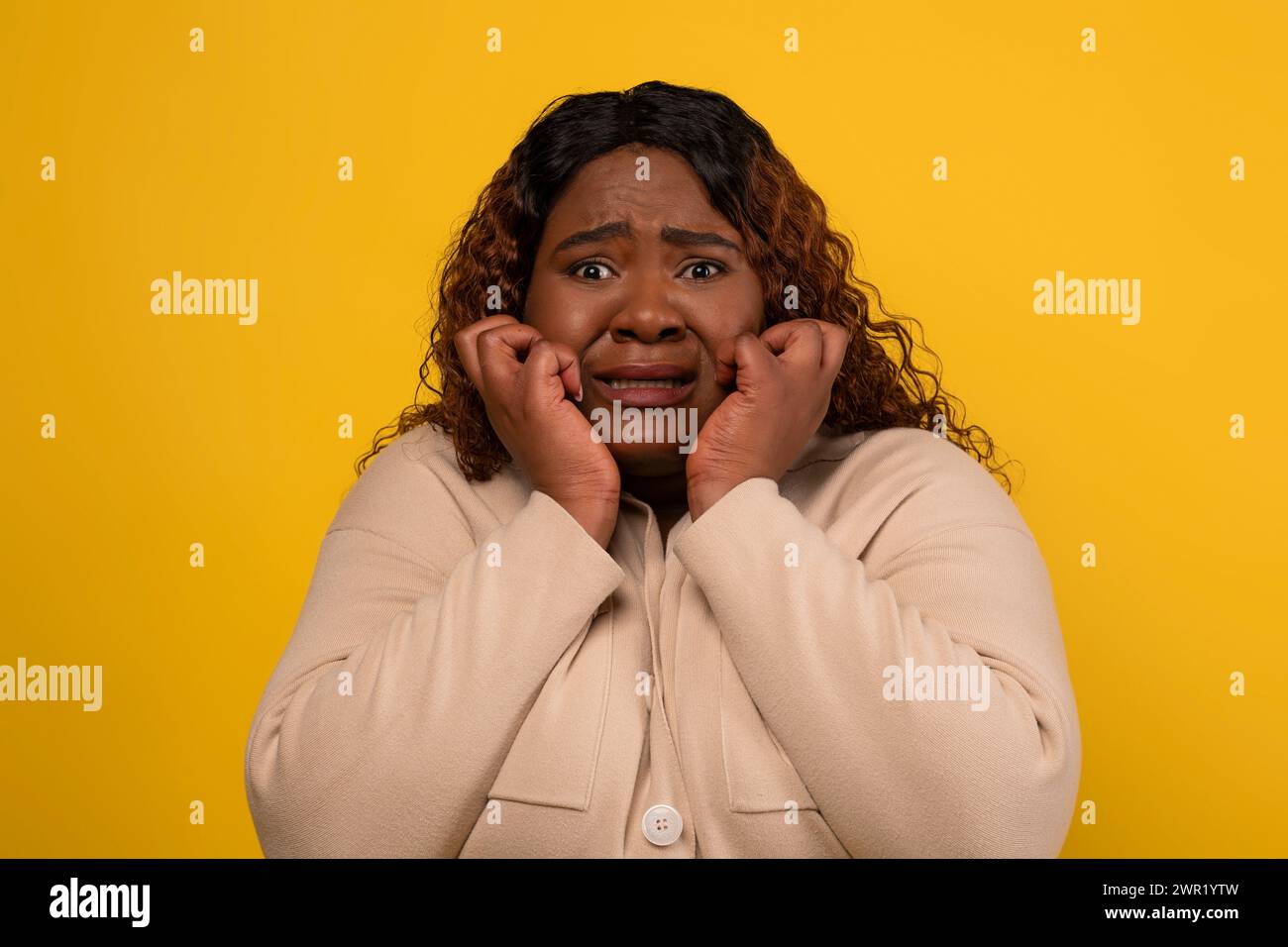 Scared millennial african american woman grimacing on yellow Stock ...