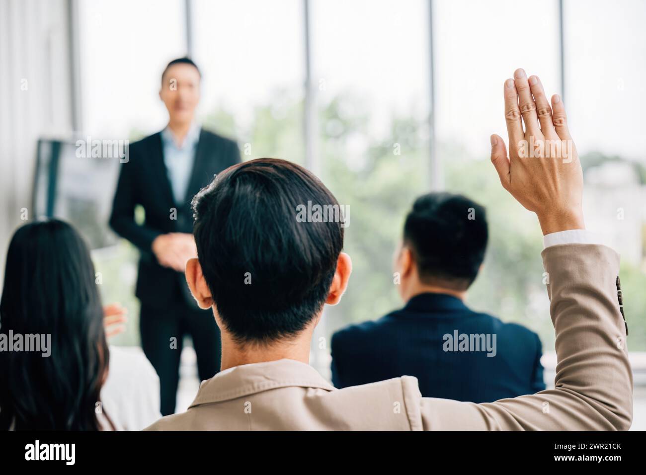 A conference audience with raised hands for questions, illustrating an ...