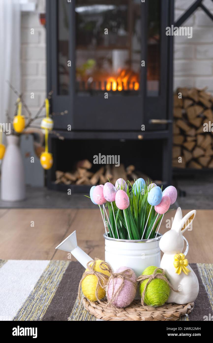 Easter decor near fireplace stove with fire and firewood. Cozy home ...