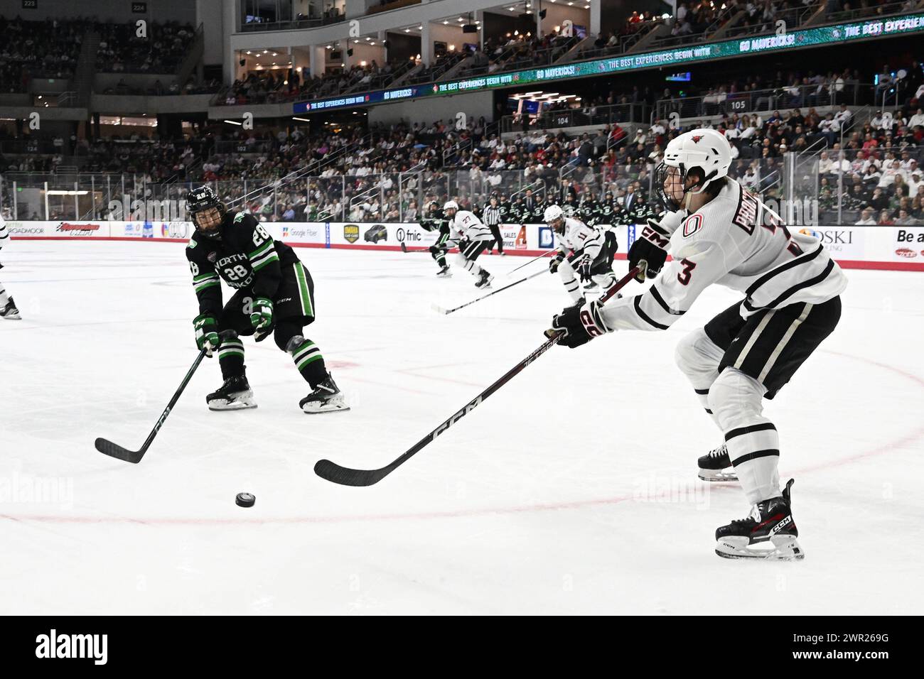 Omaha Mavericks defenseman Kirby Proctor (3) passes the puck past North Dakota Fighting Hawks ...