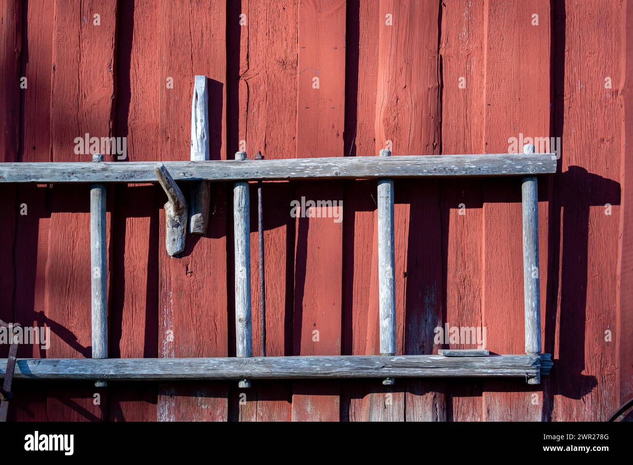 Wood rustic ladder hanging on red painted wood wall Stock Photo - Alamy