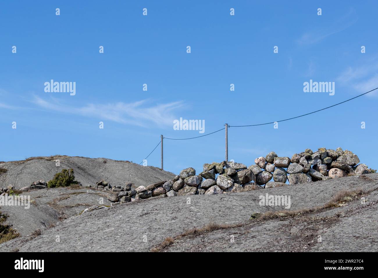 Rocks and vegetation with blue sky background with light clouds ...