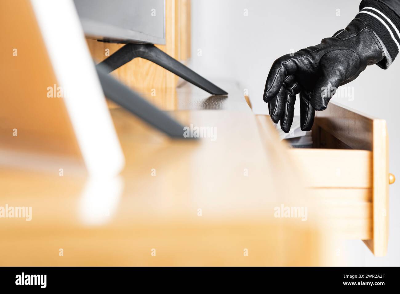 The hand of an unknown person wearing a black glove reaching into the ...