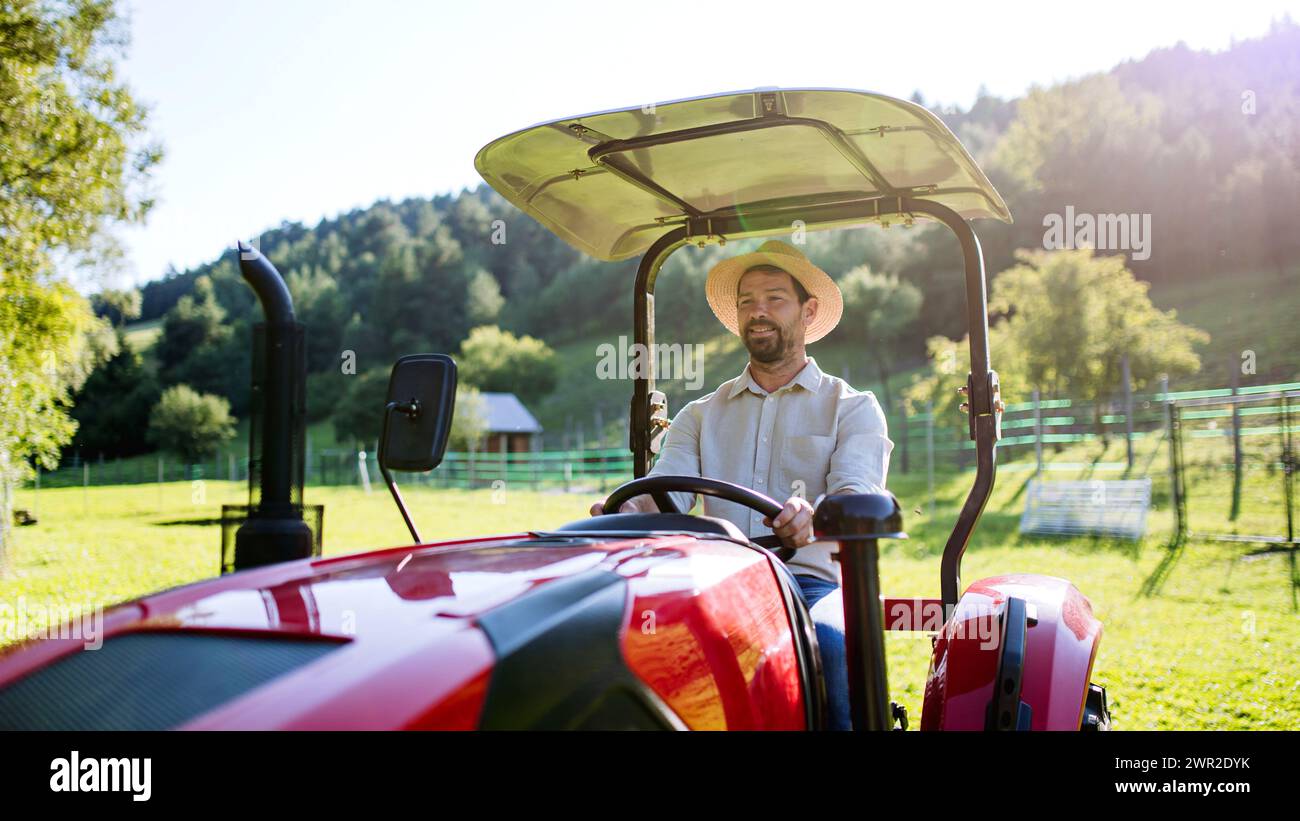 Farmer riding tractor on field. Harvesting crops, collecting vegetables ...