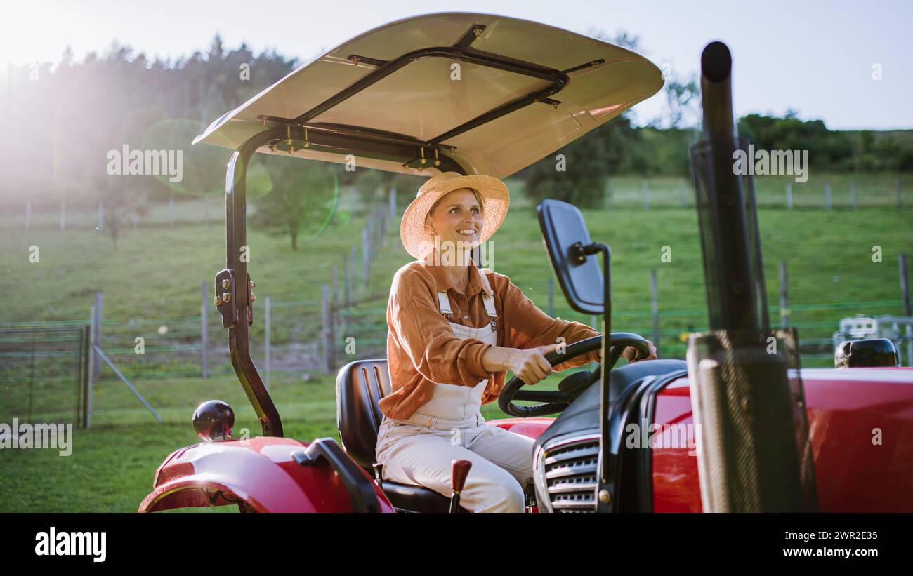 Progressive female farmer driving tractor on her own farm Stock Photo ...