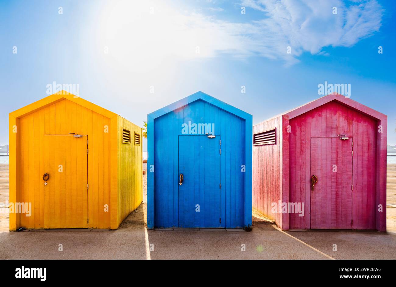 beach huts colorful yellow, blue and pink Stock Photo - Alamy