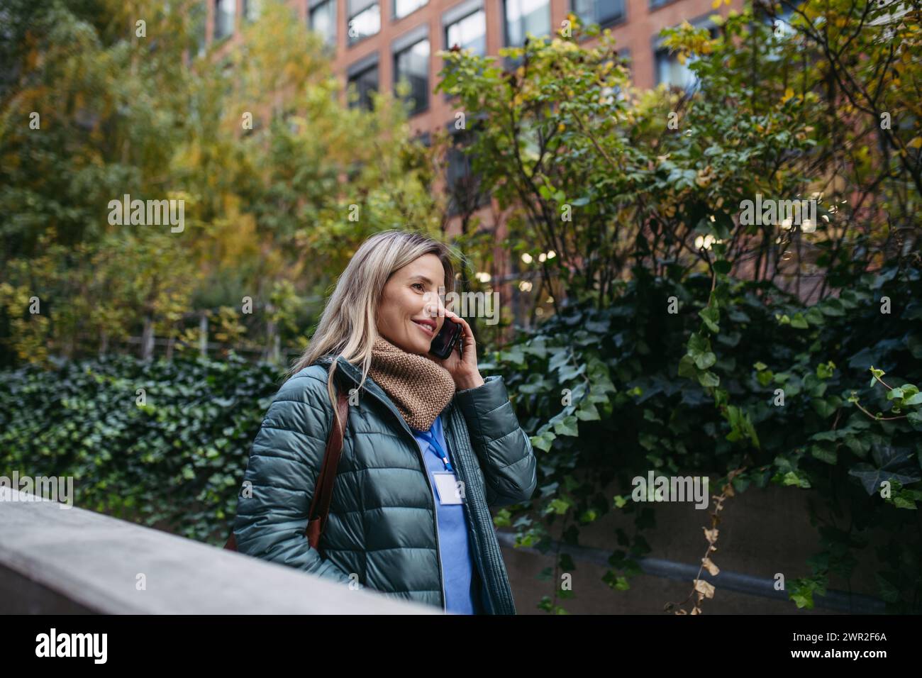 Female nurse, doctor going home from work, phone calling on smartphone ...