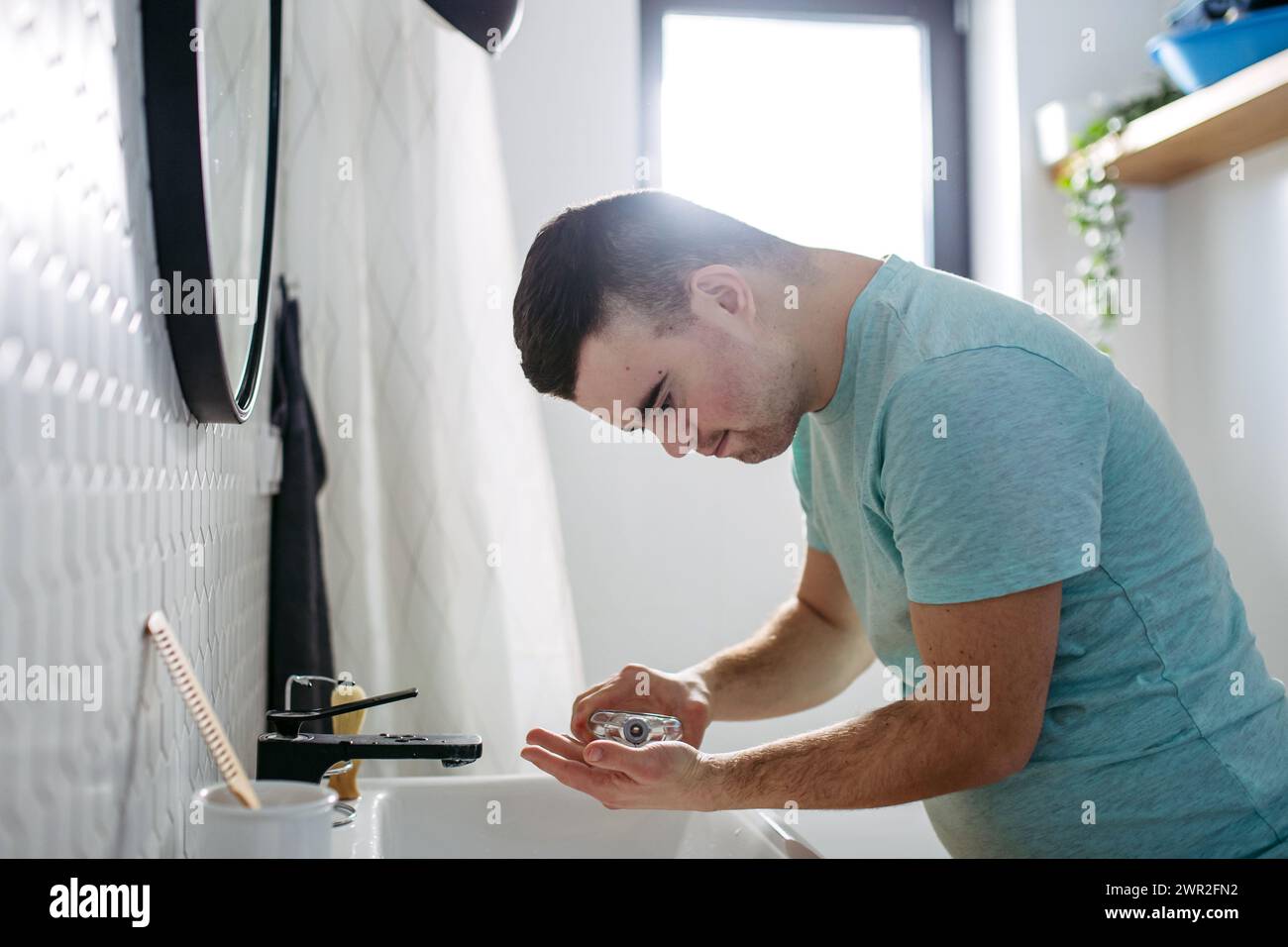 Young man with down syndrome learning how to shave, applying after shave lotion on face Stock ...