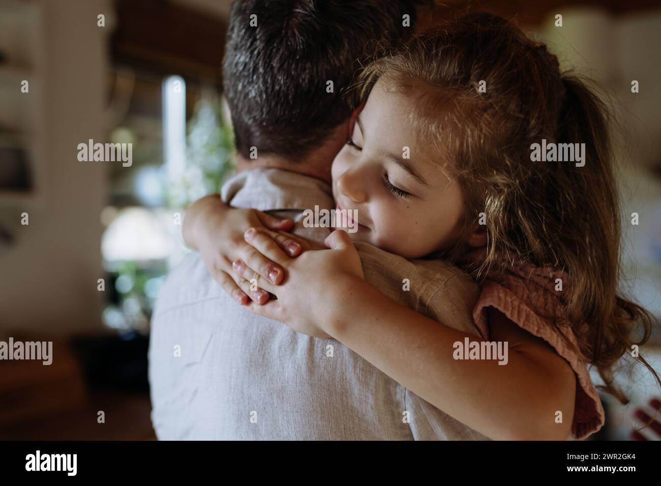 Daughter hugging father lovingly, closed eyes. Unconditional paternal ...