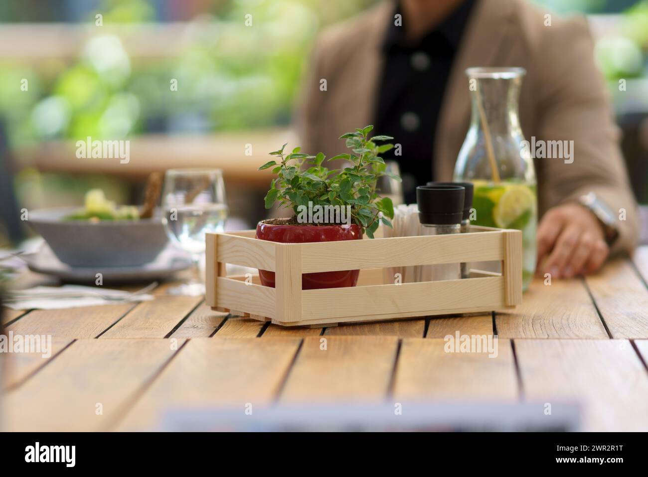 Wooden table on restaurant patio. Dining table with salt, spices ...