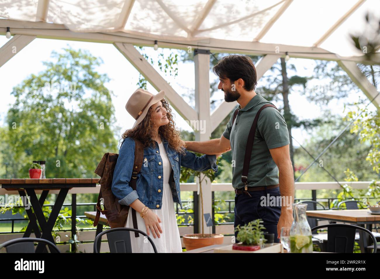 Friends meeting at a restaurant terrace. Greeting, hugging, after long ...