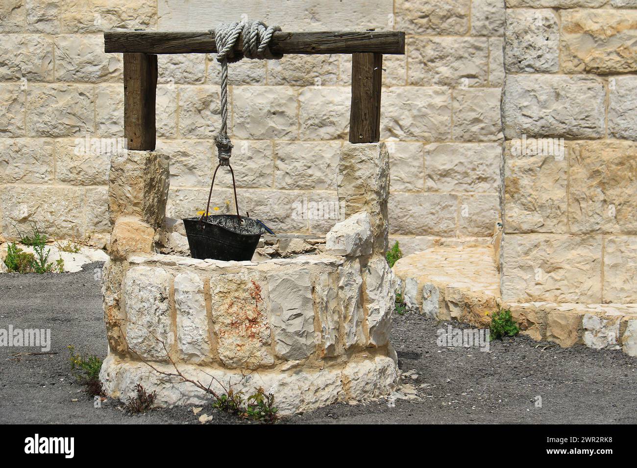 A rustic well made of stone with a metallic bucket in a Lebanese ...