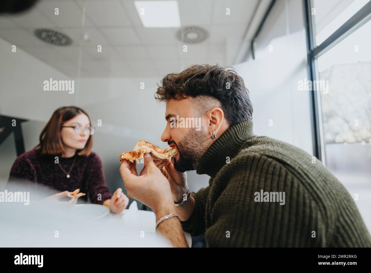 Multiracial colleagues enjoying a pizza break, fostering teamwork and ...