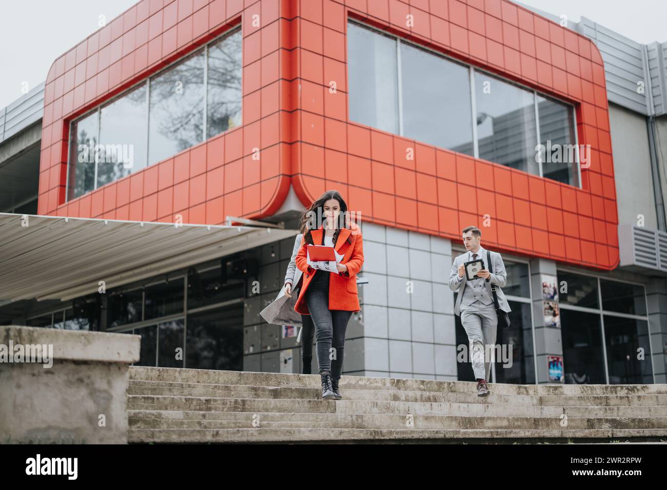 Dynamic business partners in casual attire walking outside an office ...